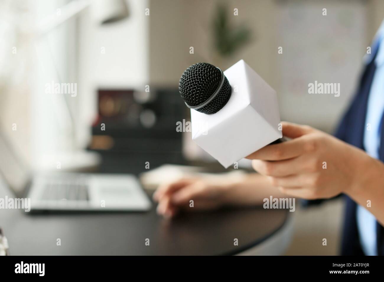 Female journalist with microphone having an interview in office ...