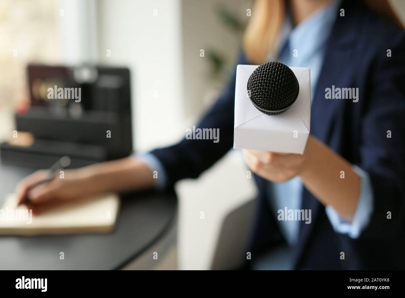 Female journalist with microphone having an interview in office ...