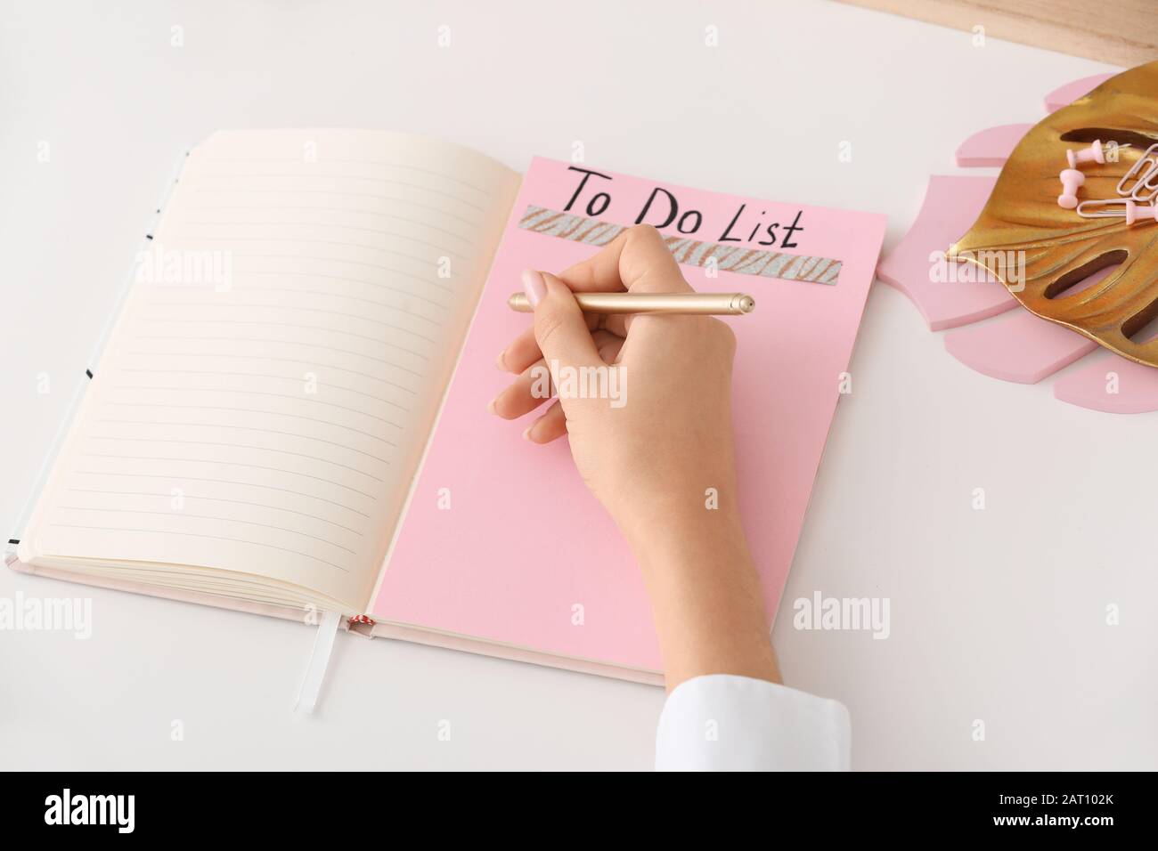 Woman making to do list at table Stock Photo - Alamy