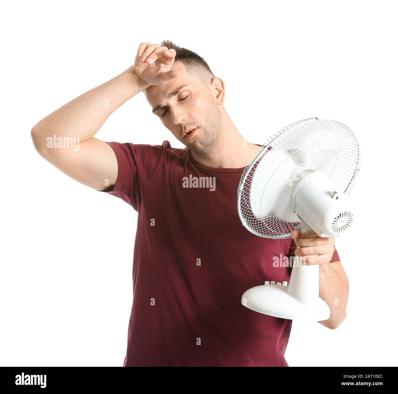 Young man with electric fan on white background Stock Photo - Alamy