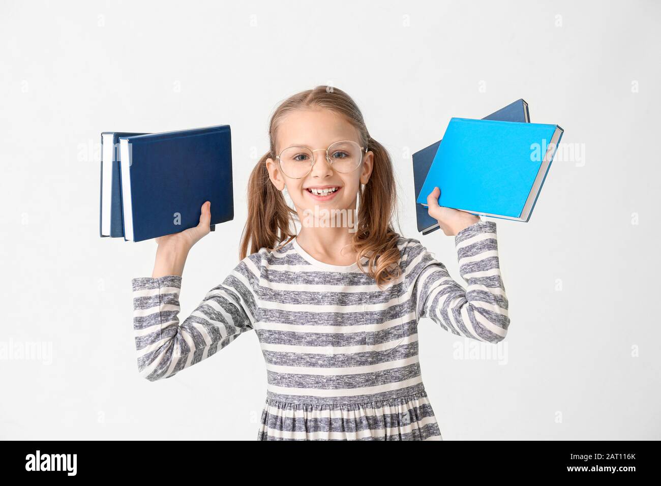 Cute little girl with books on white background Stock Photo - Alamy