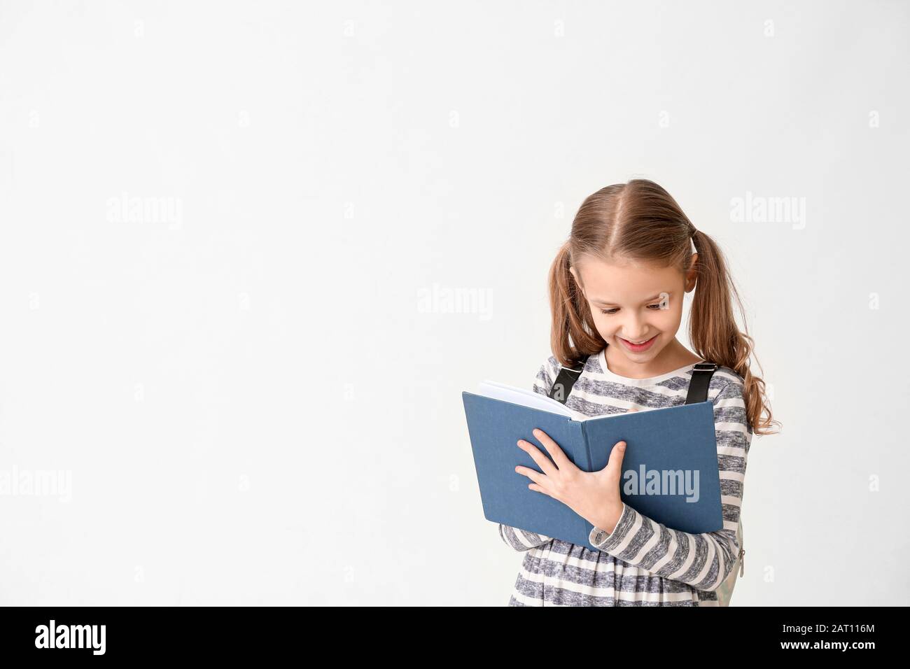 Cute little girl with notebook on white background Stock Photo - Alamy