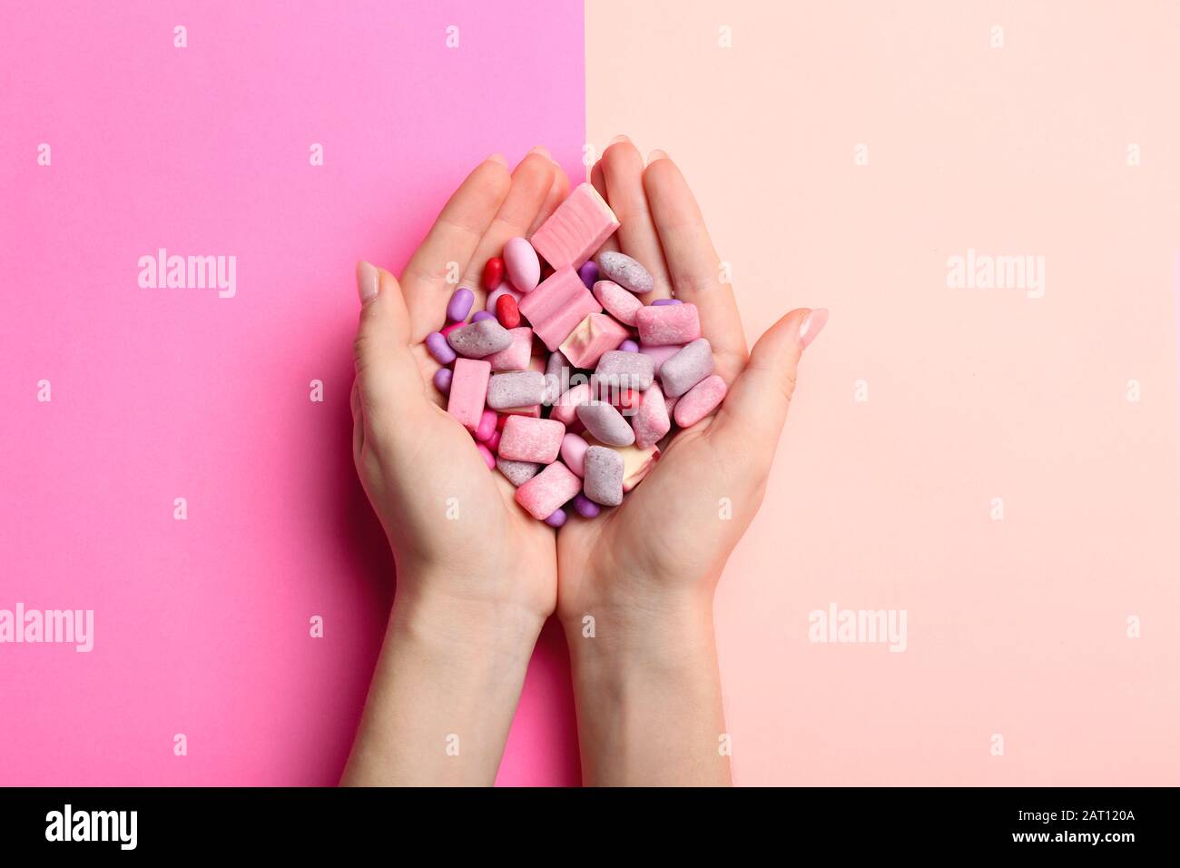 Female hands with chewing gums on color background Stock Photo - Alamy