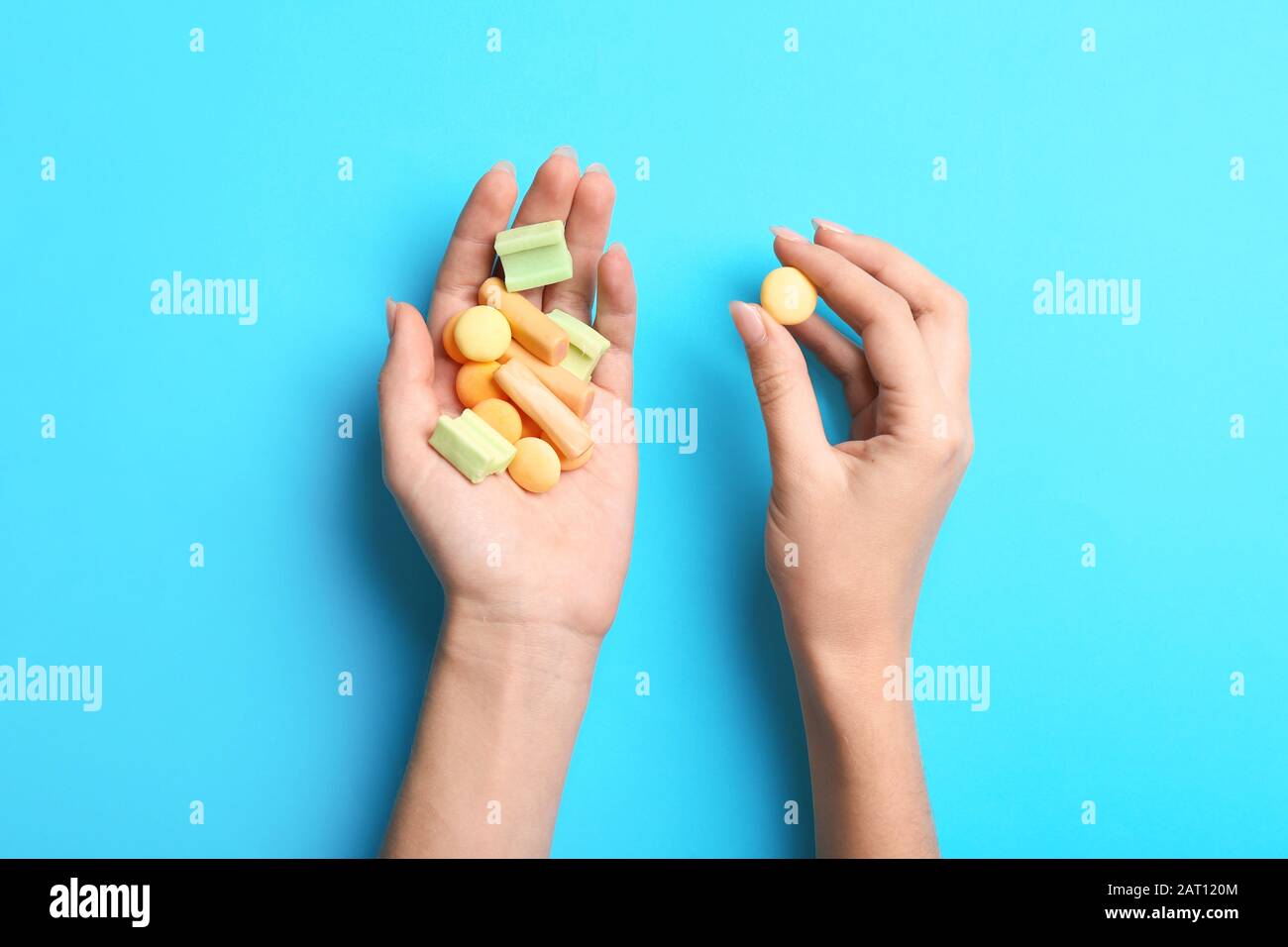 Female hands with chewing gums on color background Stock Photo - Alamy