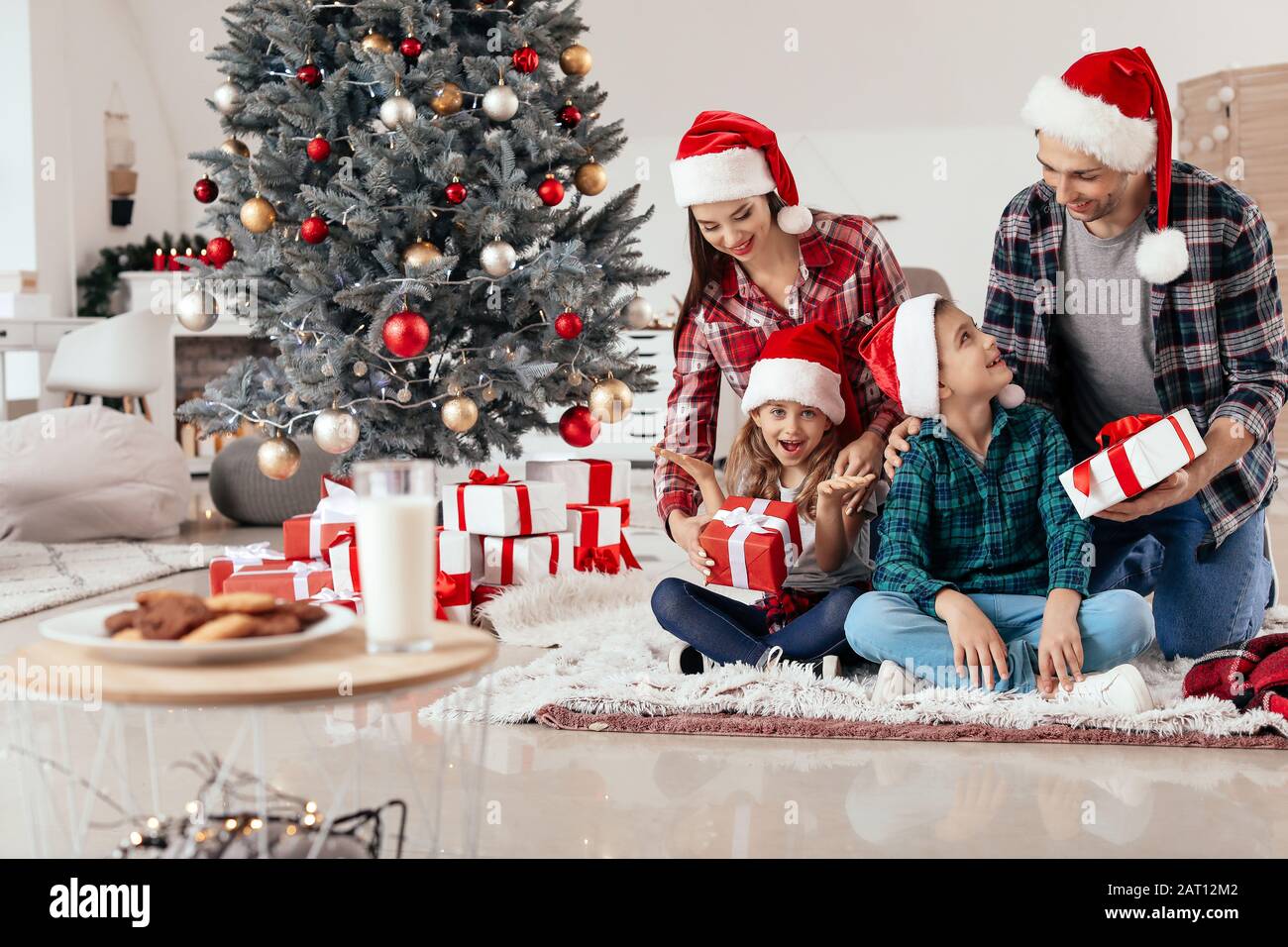 Parents greeting their children at home on Christmas eve Stock Photo ...