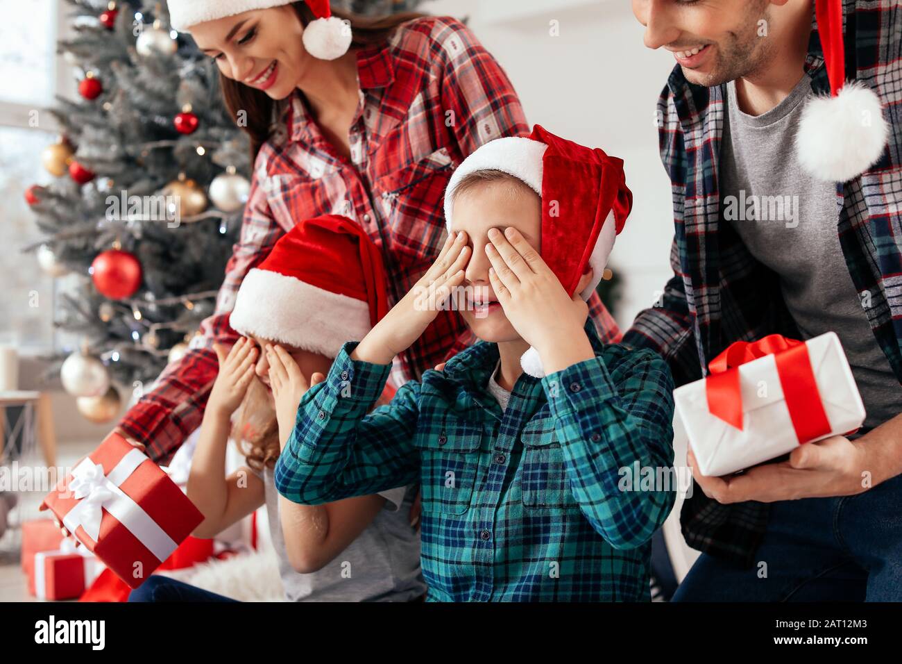 Parents greeting their children at home on Christmas eve Stock Photo ...