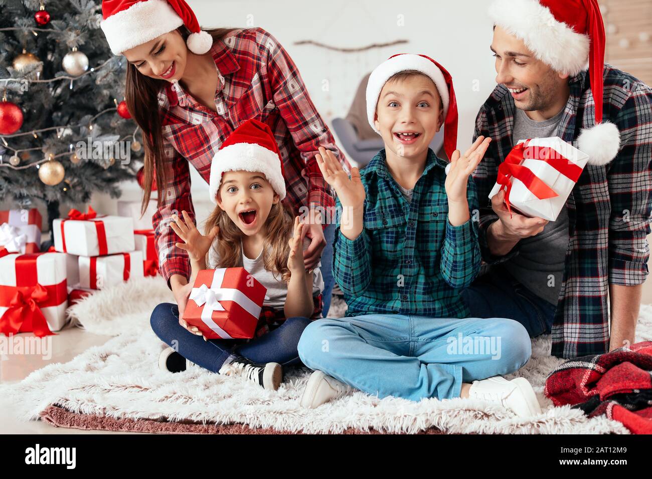 Parents greeting their children at home on Christmas eve Stock Photo ...