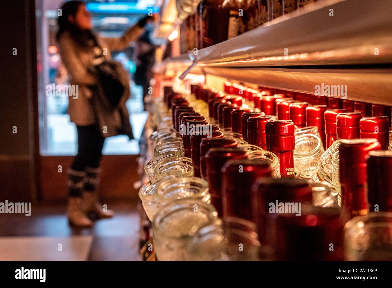 Perspective view of a bokeh of a woman shopping for wine or other ...