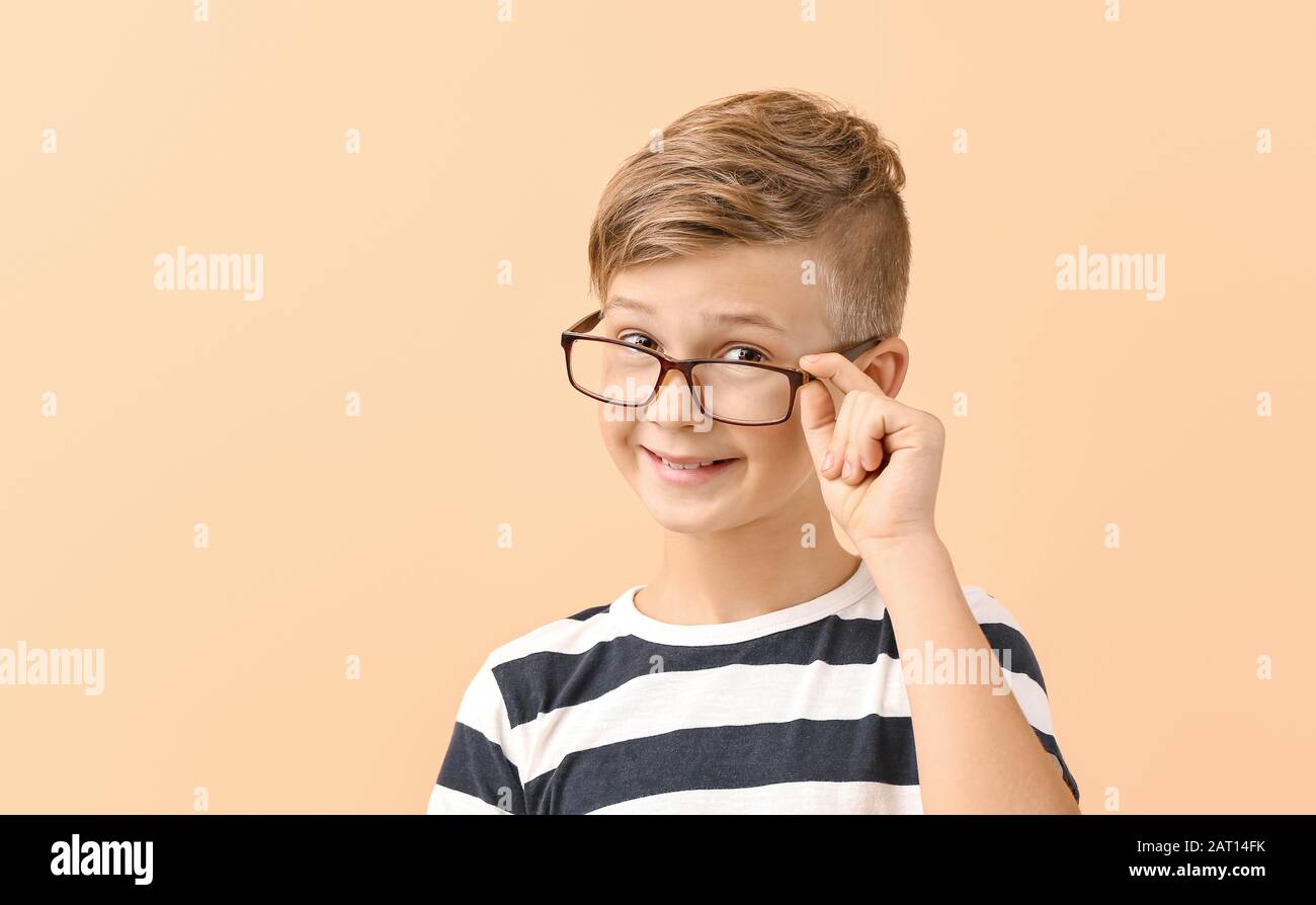 Cute little boy with eyeglasses on color background Stock Photo - Alamy