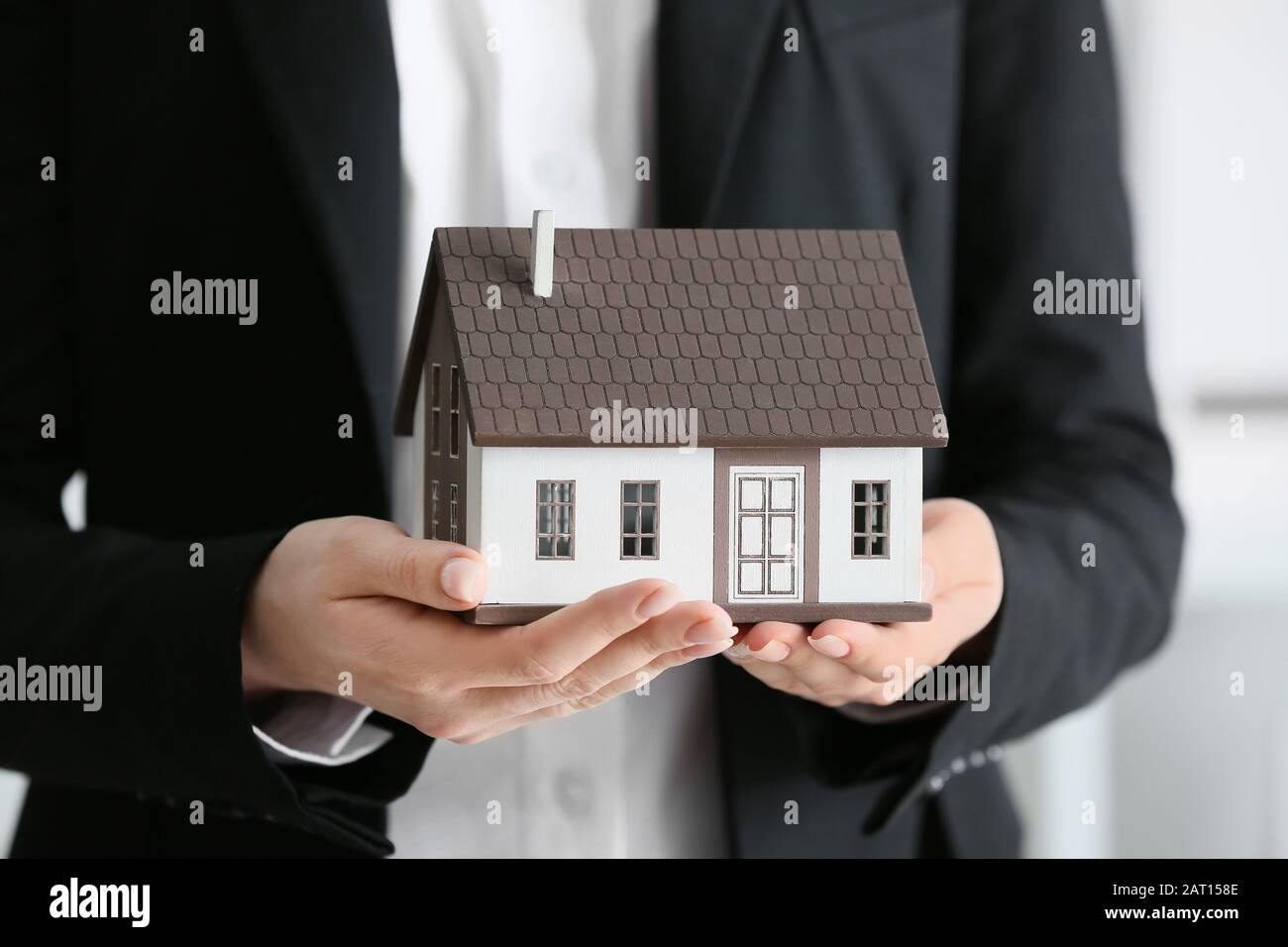 Real estate agent with model of house, closeup Stock Photo - Alamy