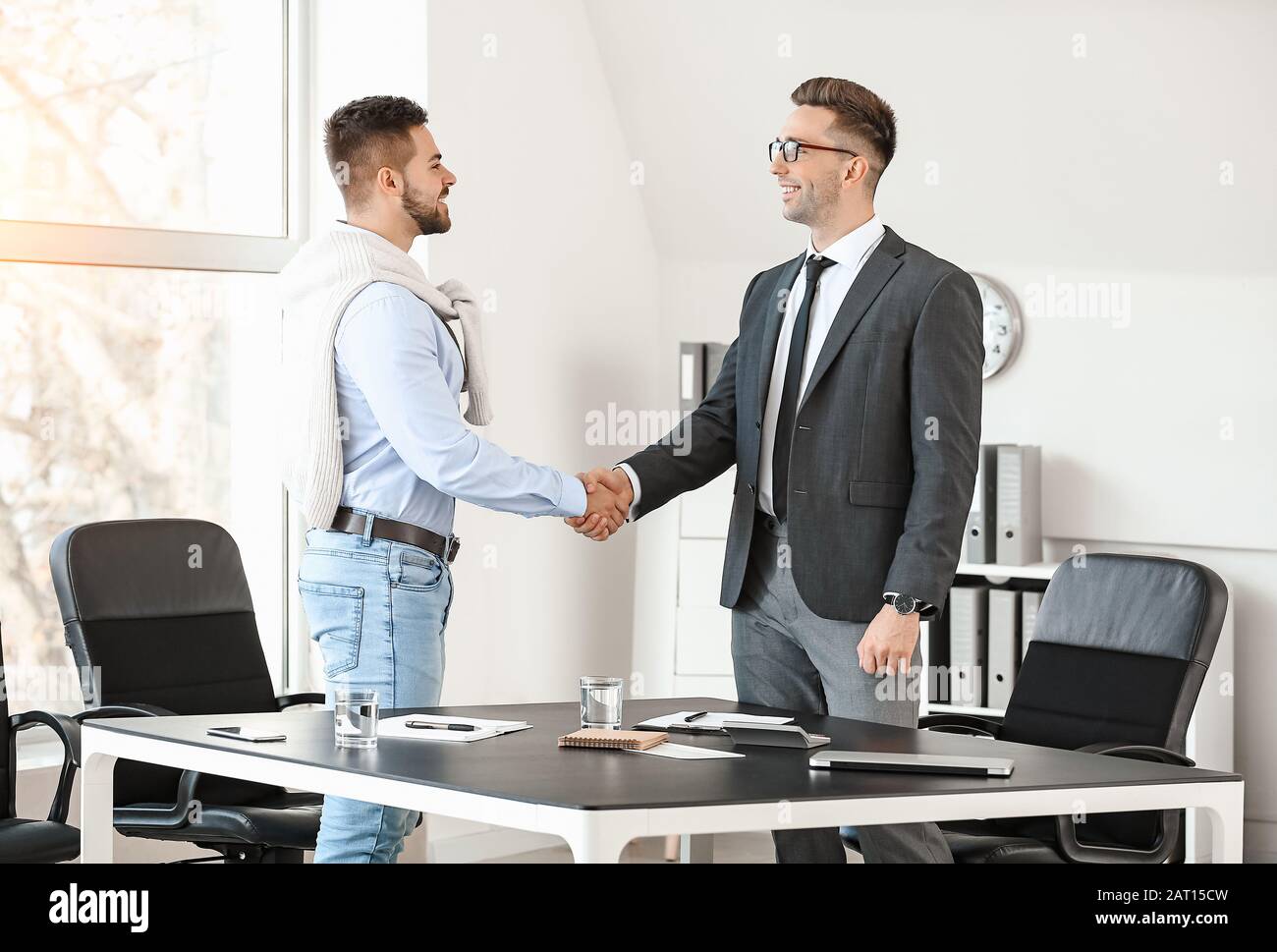 Bank manager and man shaking hands in office Stock Photo - Alamy
