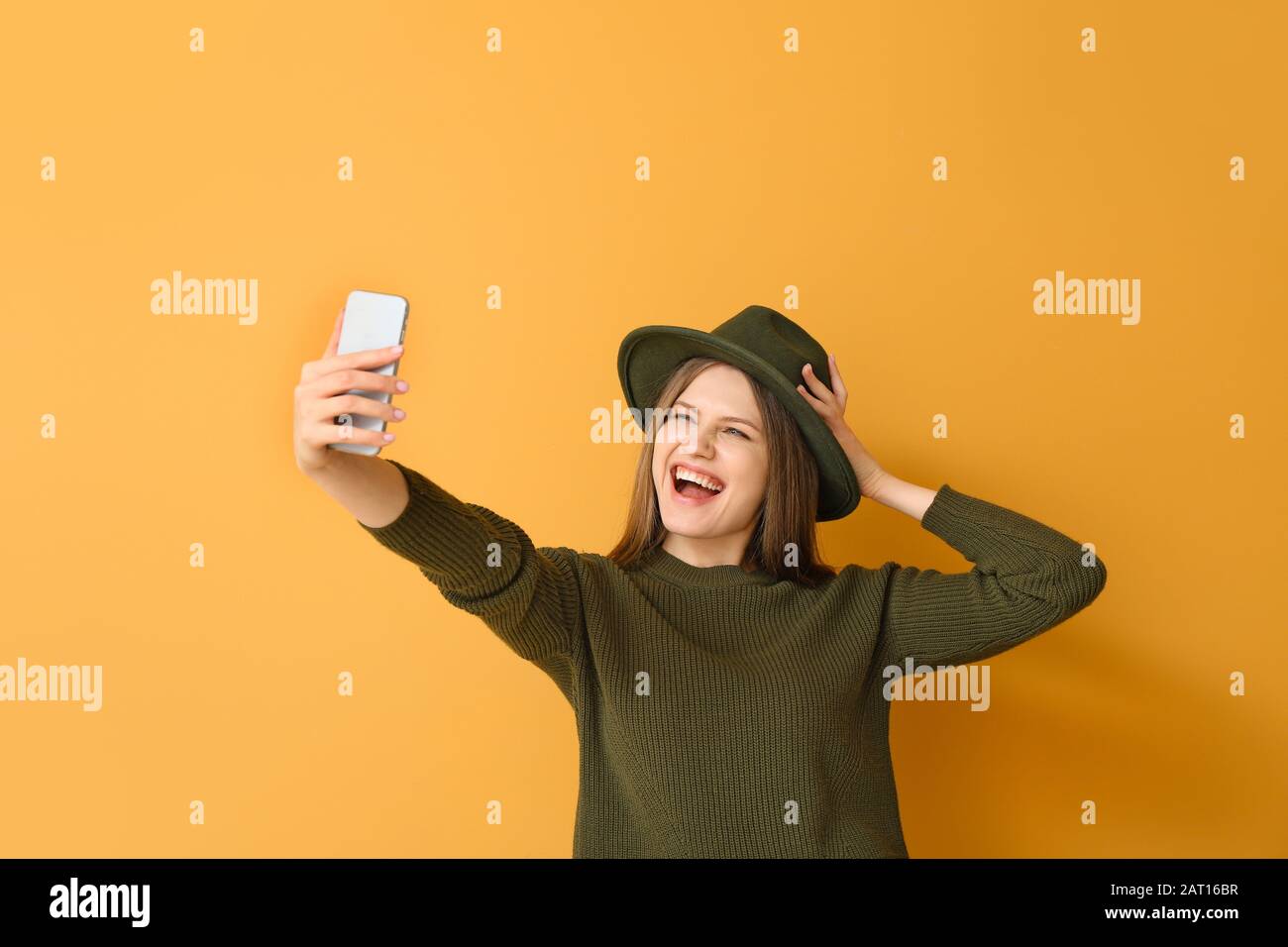 Beautiful young woman taking selfie on color background Stock Photo - Alamy