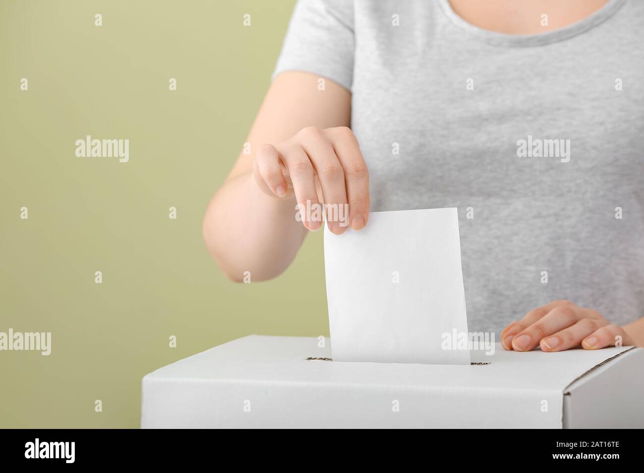 Voting woman near ballot box on color background Stock Photo - Alamy