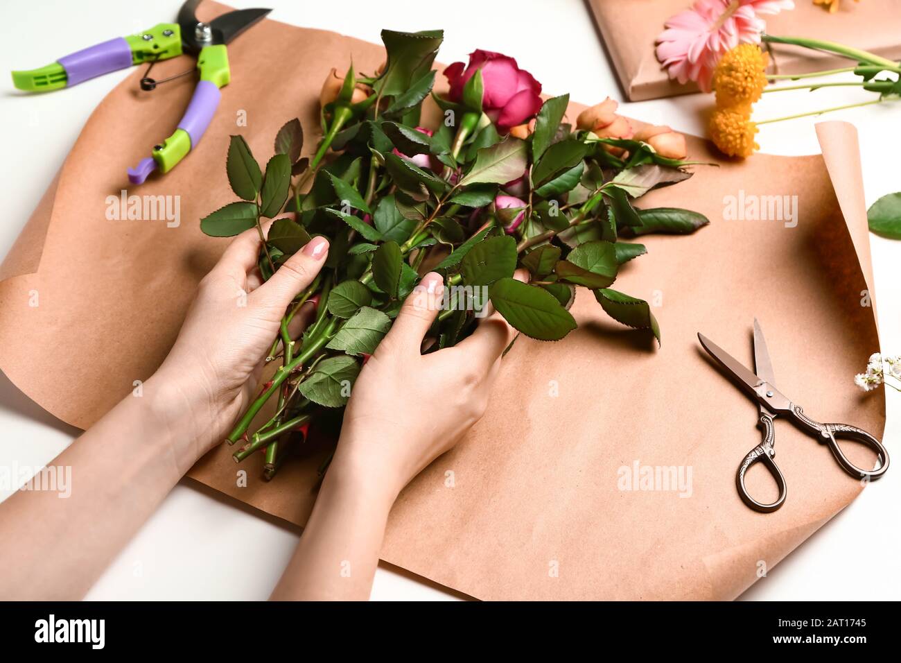 Female florist making beautiful bouquet on white background Stock Photo ...
