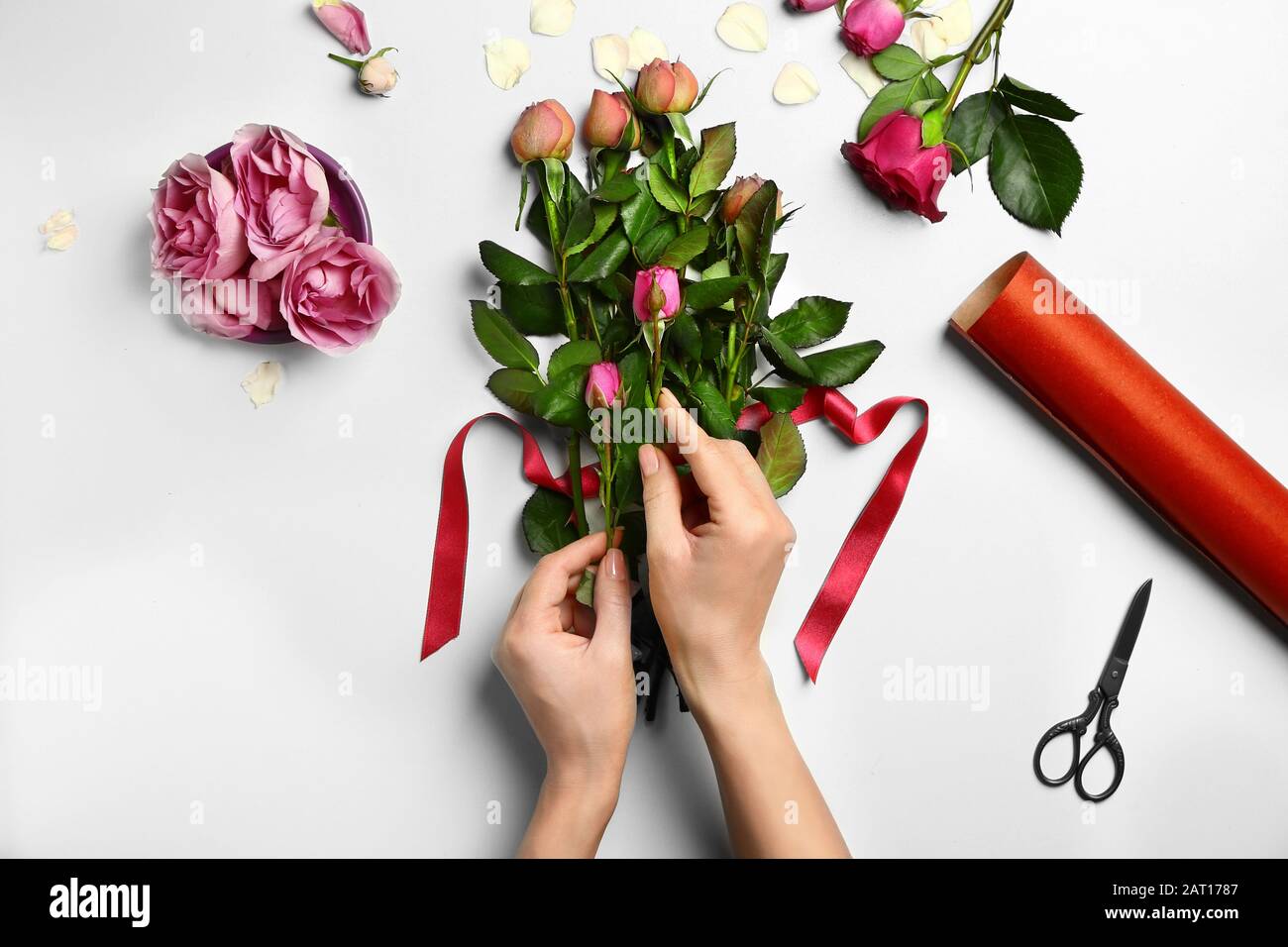 Female florist making beautiful bouquet on white background Stock Photo ...