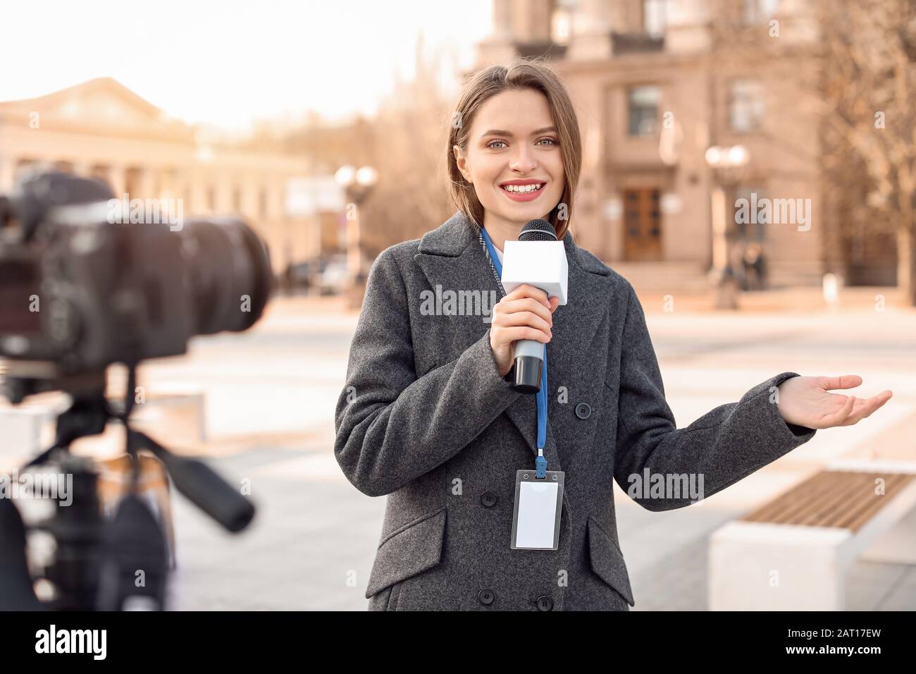 Beautiful journalist with microphone outdoors Stock Photo - Alamy