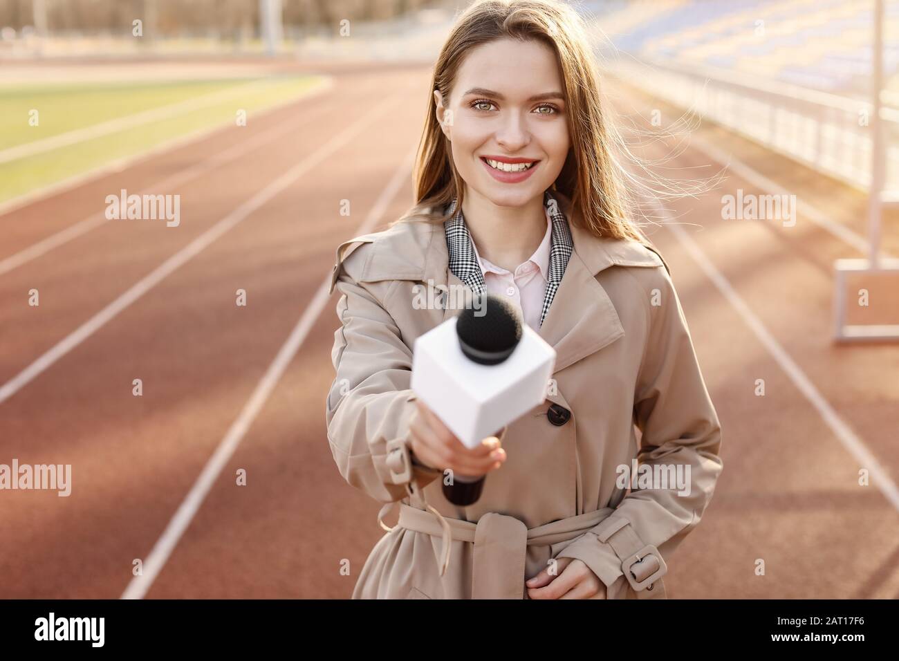 Beautiful reporter with microphone at the stadium Stock Photo - Alamy