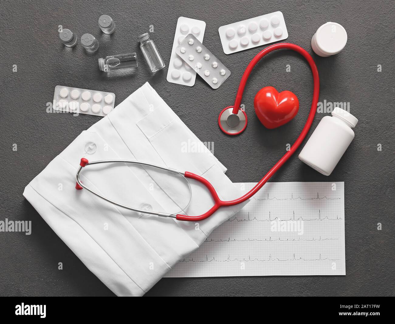 Stethoscope, doctor's uniform, cardiogram, heart and pills on grey ...