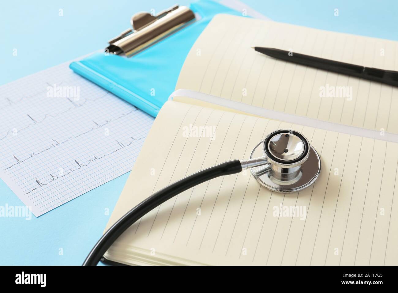 Stethoscope, notebook and cardiogram on color background. Cardiology ...