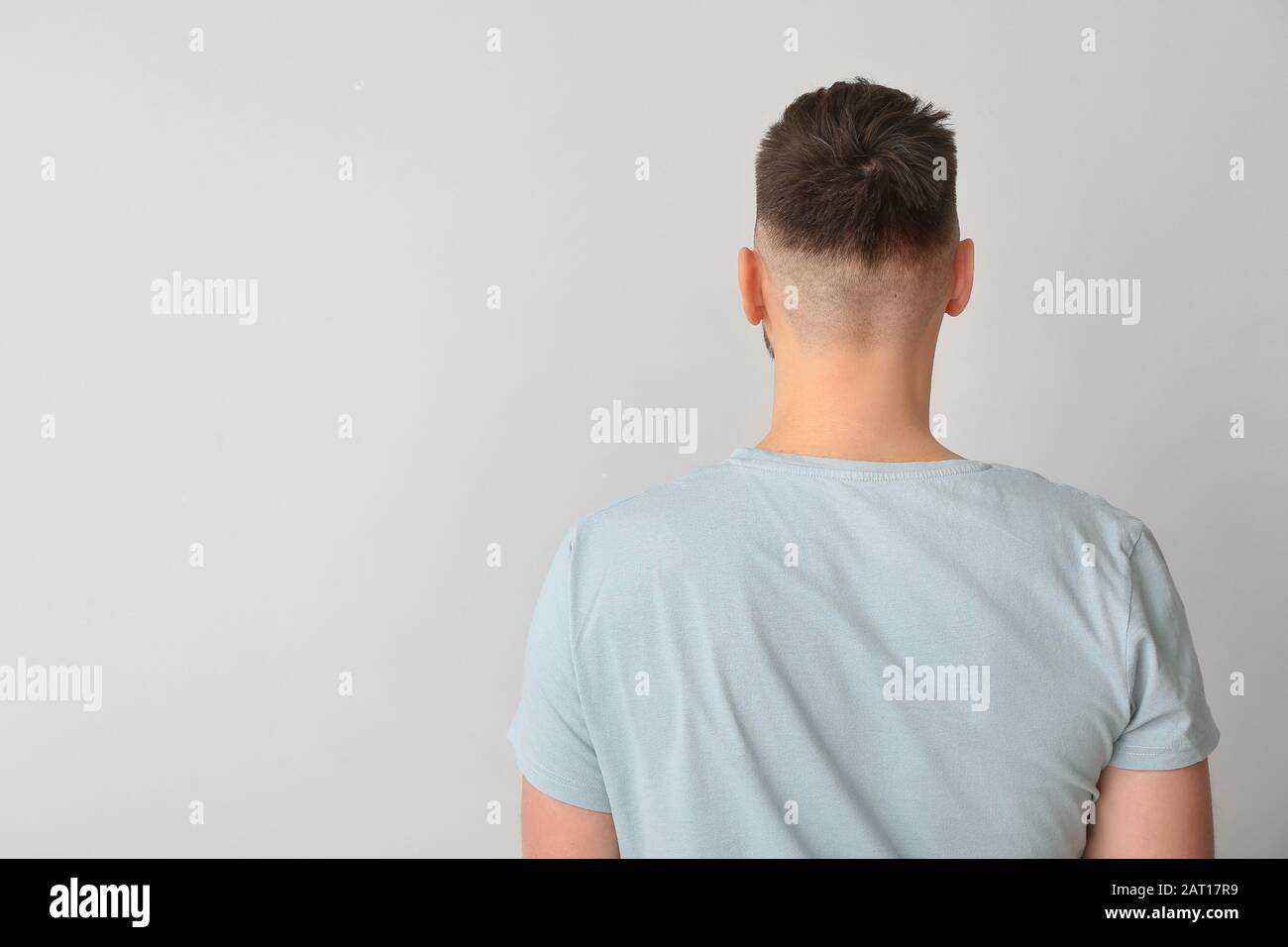 Handsome man on grey background, back view Stock Photo - Alamy