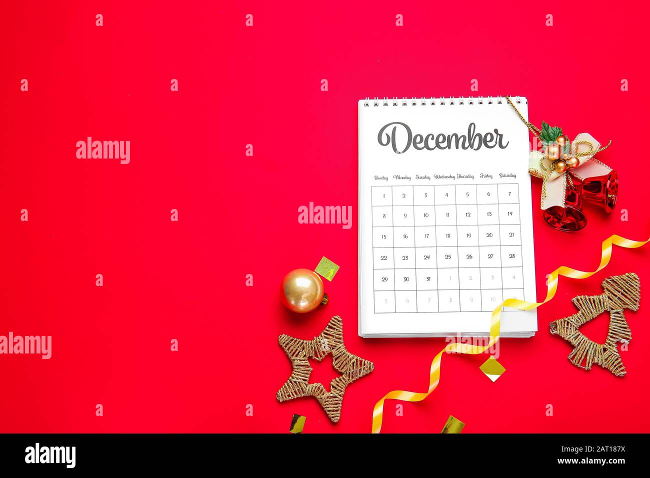 Calendar with page of December and Christmas decor on color background ...
