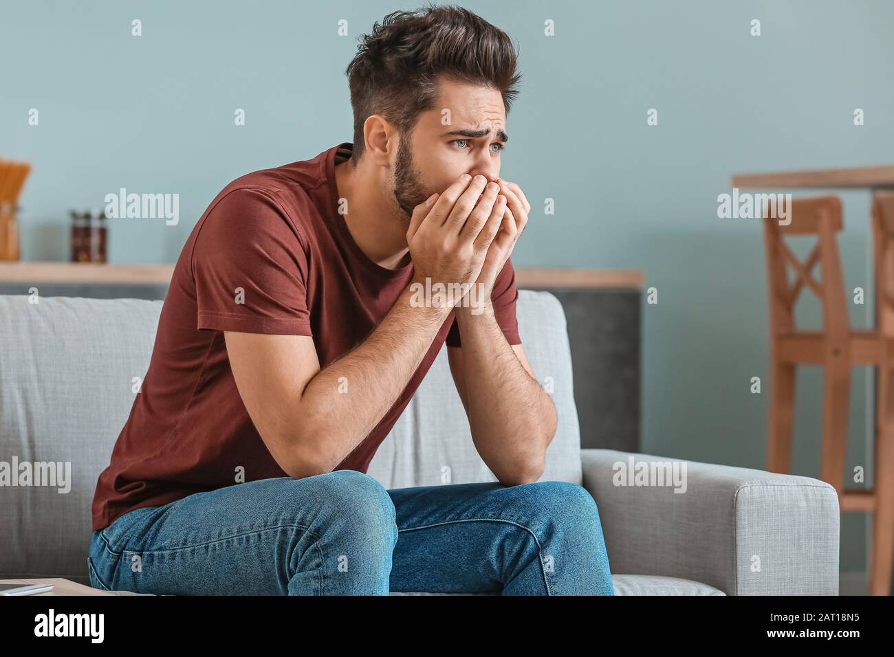 Portrait of worried young man at home Stock Photo - Alamy