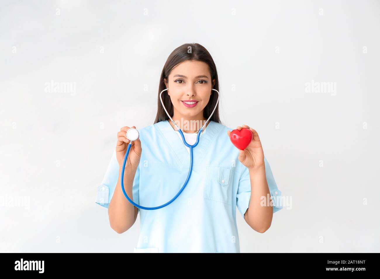 Female cardiologist on light background Stock Photo - Alamy