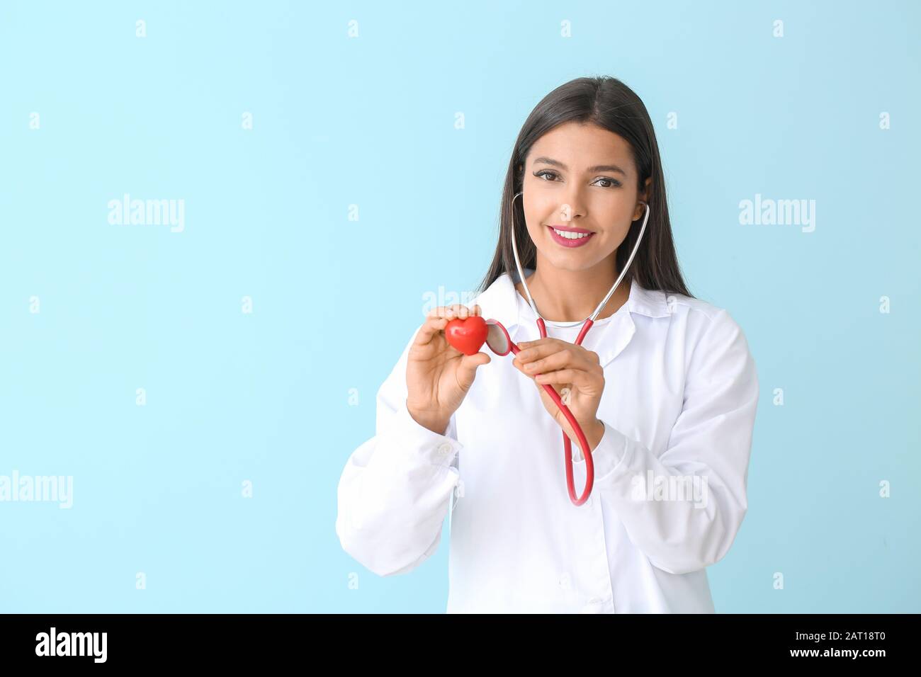 Female cardiologist on color background Stock Photo - Alamy