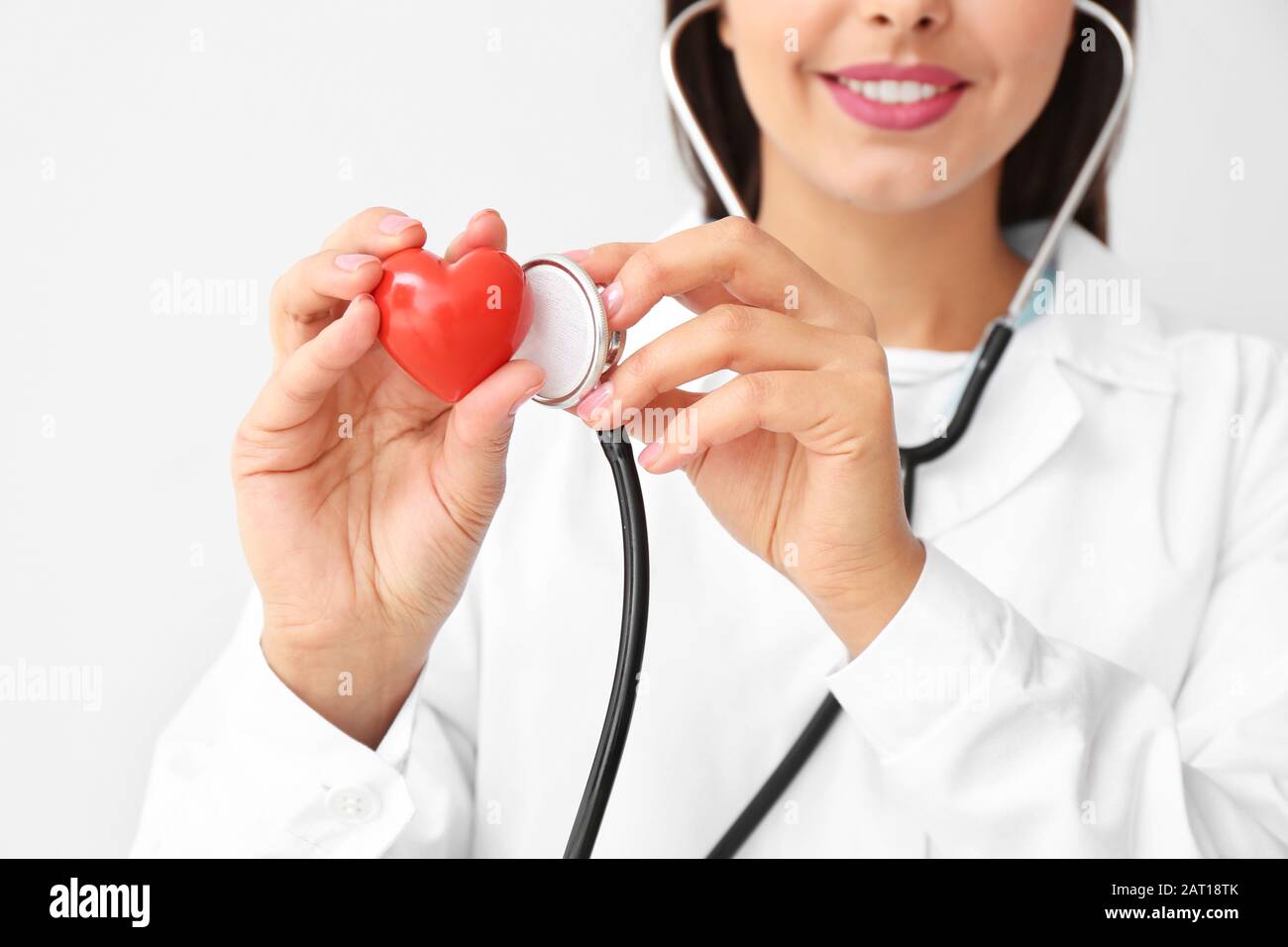 Female cardiologist on light background Stock Photo - Alamy