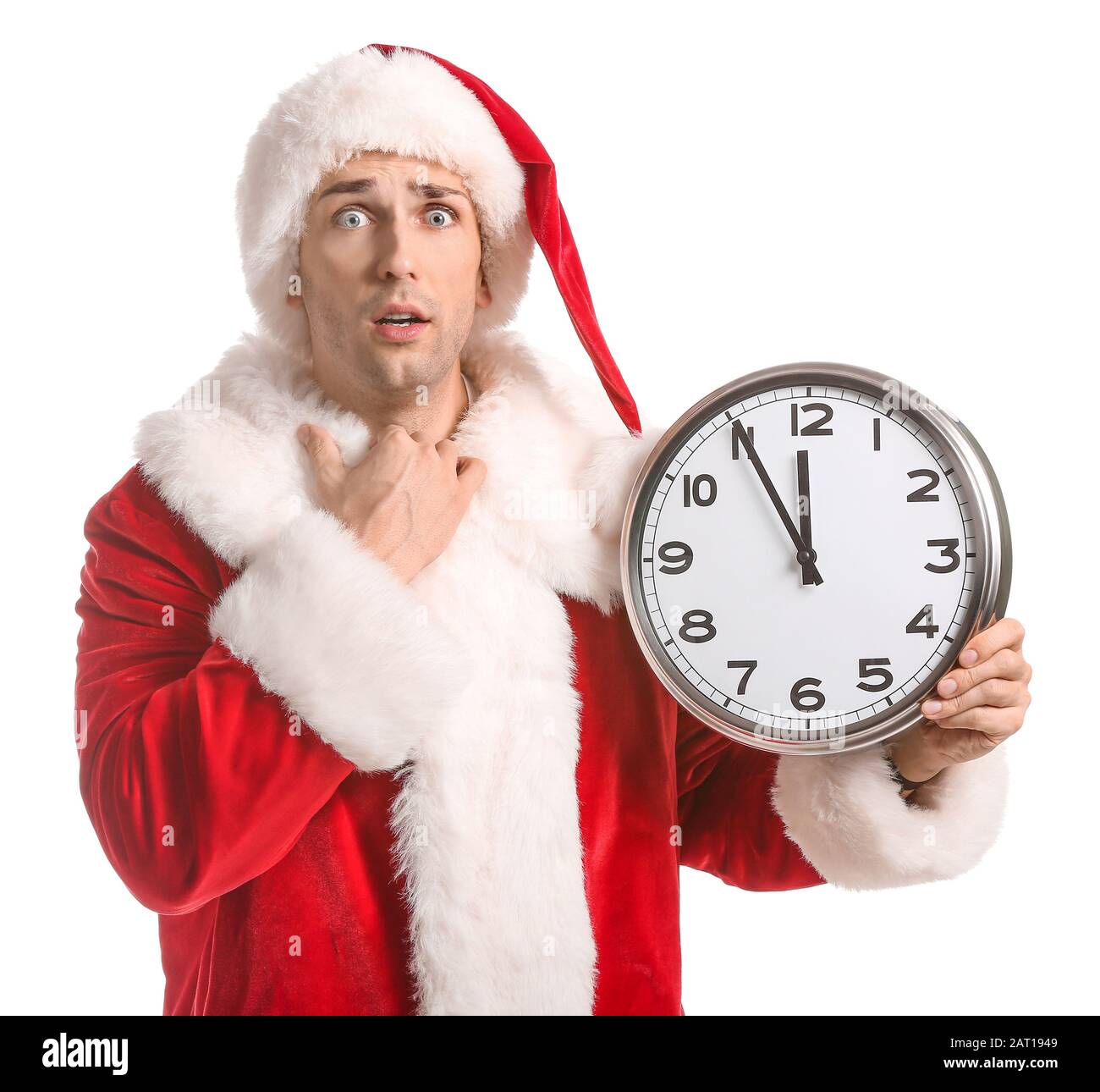 Surprised young man in Santa costume and with clock on white background ...