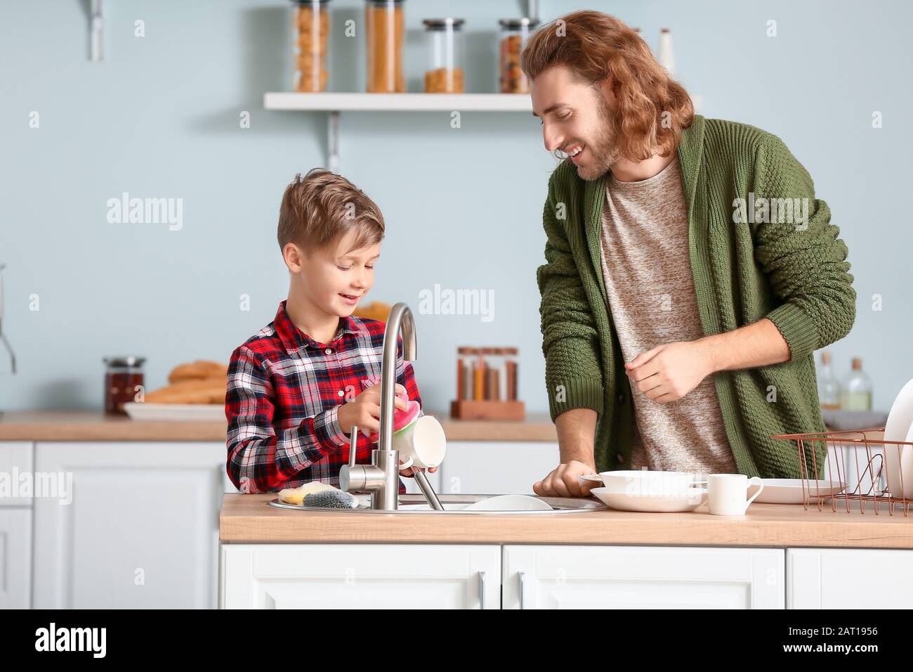 Father and son washing dishes in kitchen Stock Photo - Alamy