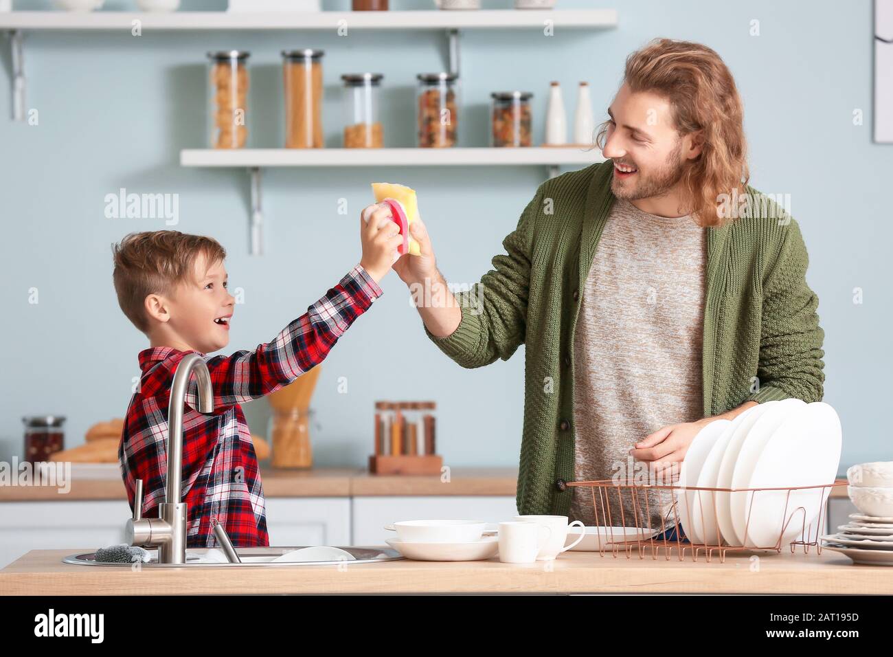 Father and son washing dishes in kitchen Stock Photo - Alamy