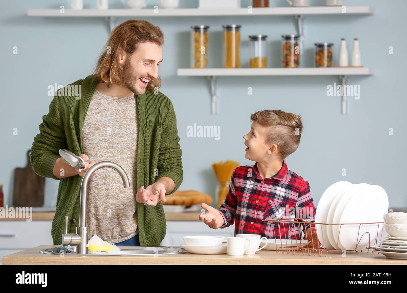 Father and son washing dishes in kitchen Stock Photo - Alamy