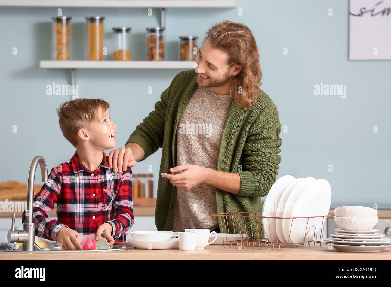 Father and son washing dishes in kitchen Stock Photo - Alamy