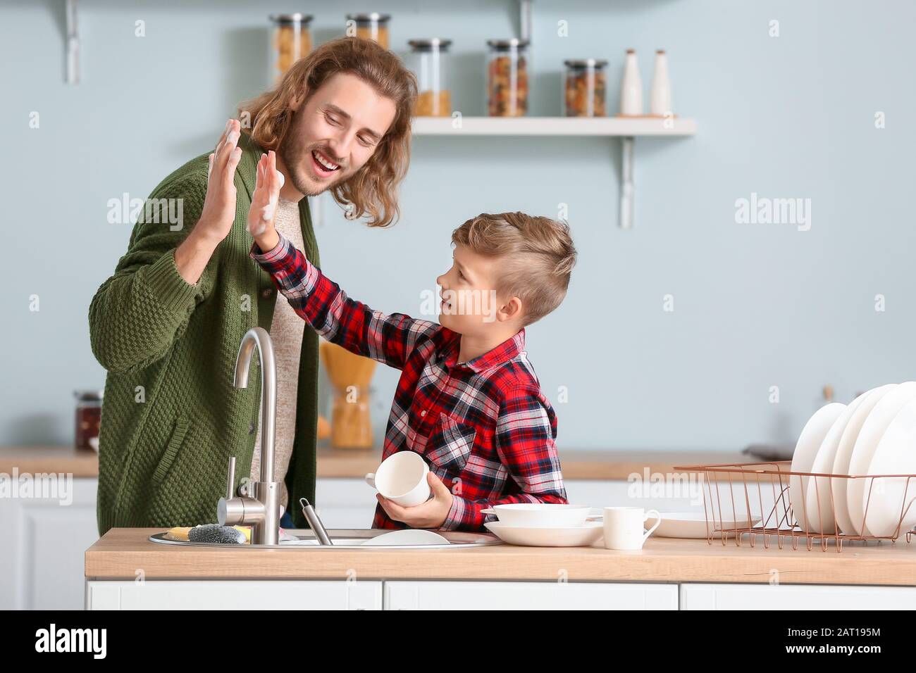 Father and son washing dishes in kitchen Stock Photo - Alamy