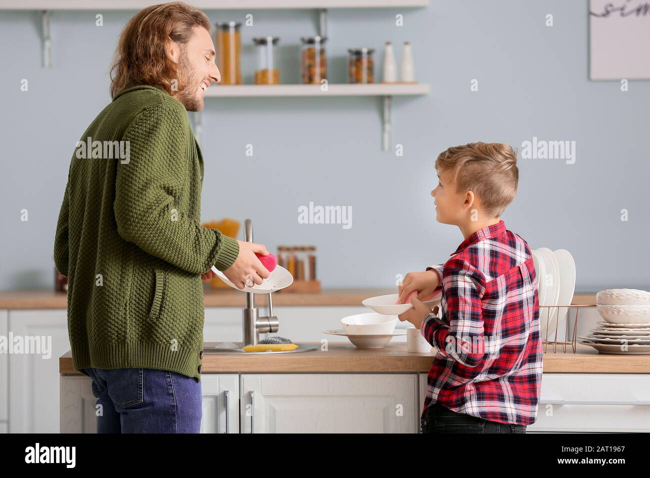 Father and son washing dishes in kitchen Stock Photo - Alamy
