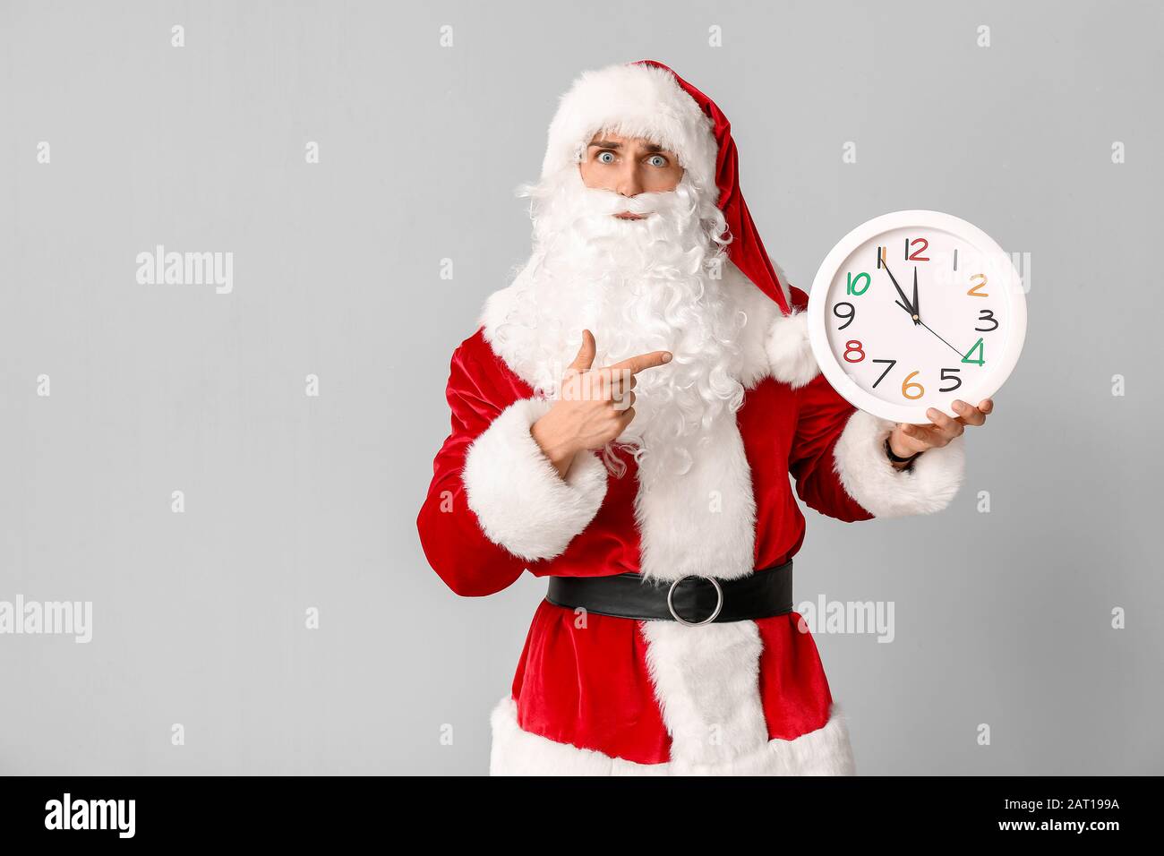 Santa Claus with clock on light background. Christmas countdown concept ...