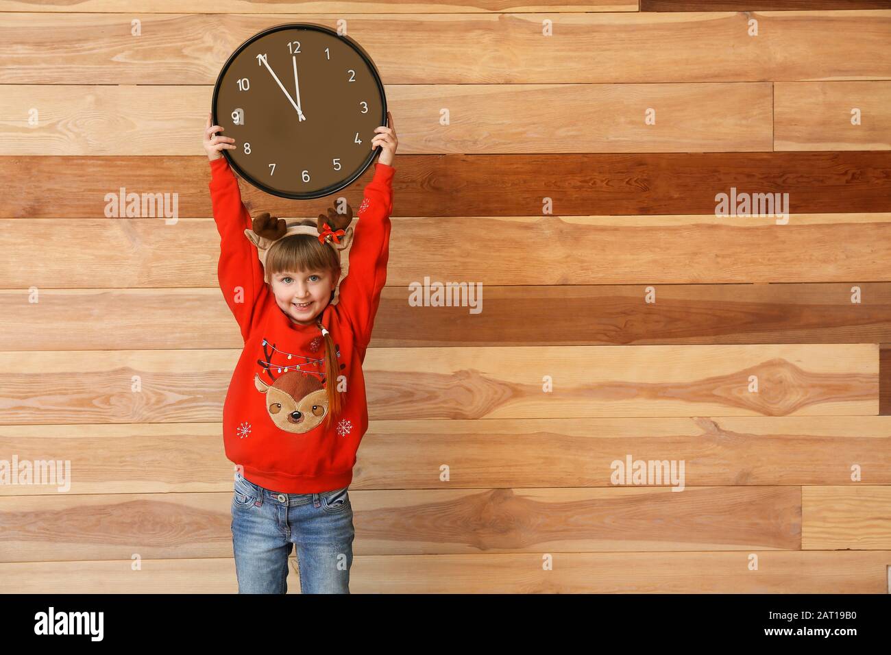 Little girl with clock on wooden background. Christmas countdown ...