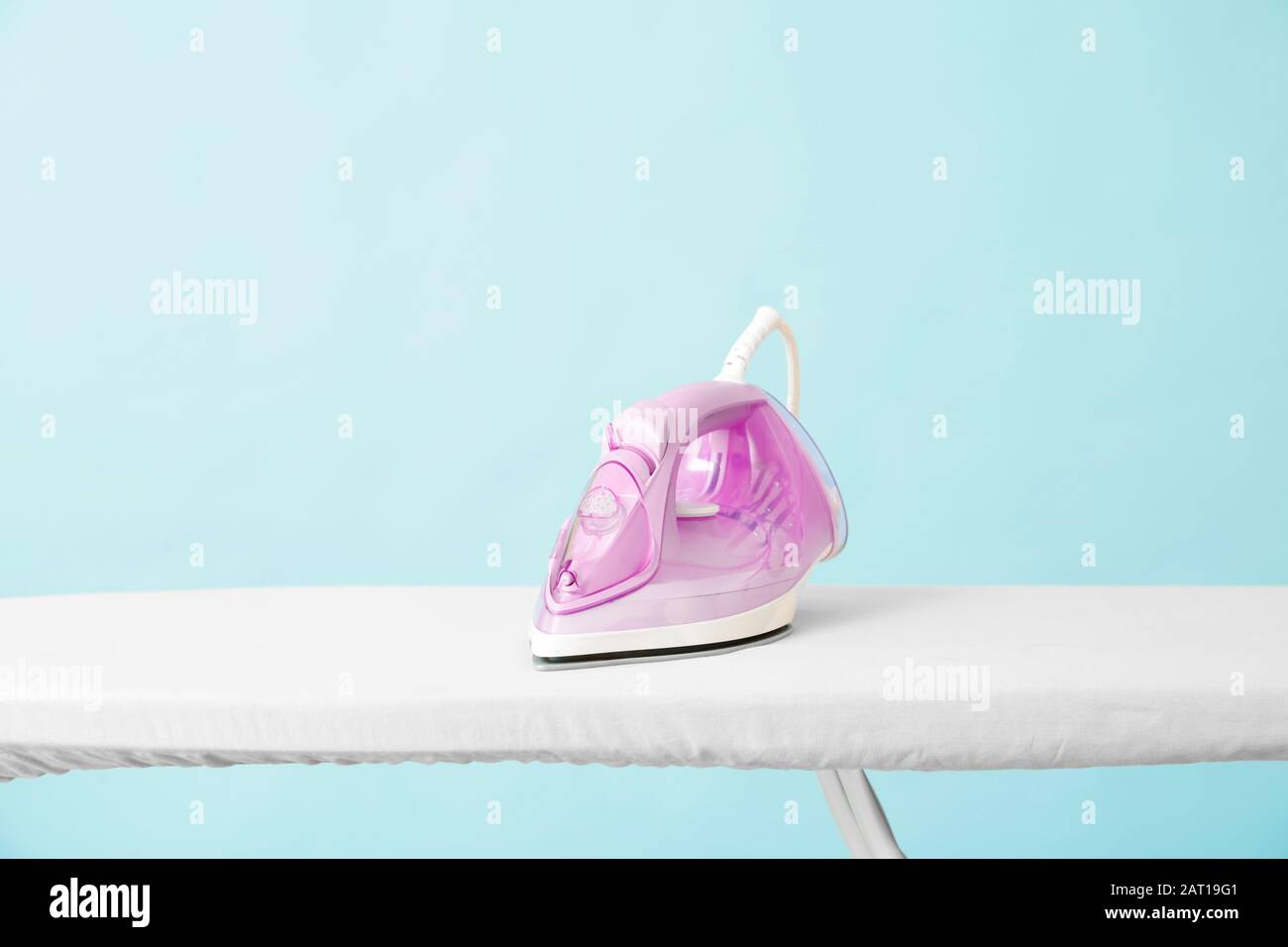 Iron on board against color background Stock Photo - Alamy