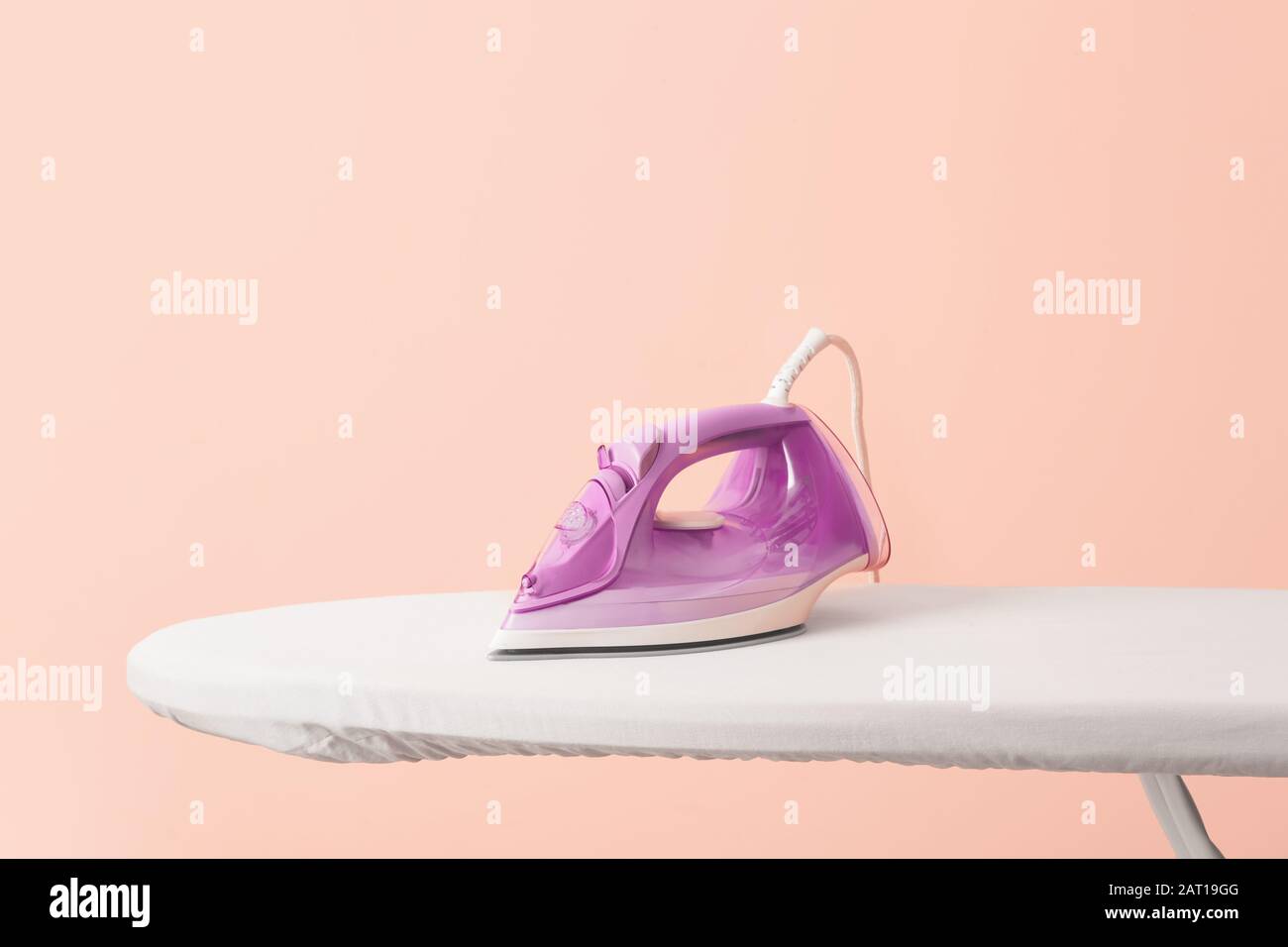 Iron on board against color background Stock Photo - Alamy