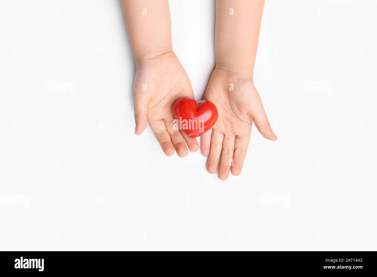 Child hands with red heart on white background. Cardiology concept ...