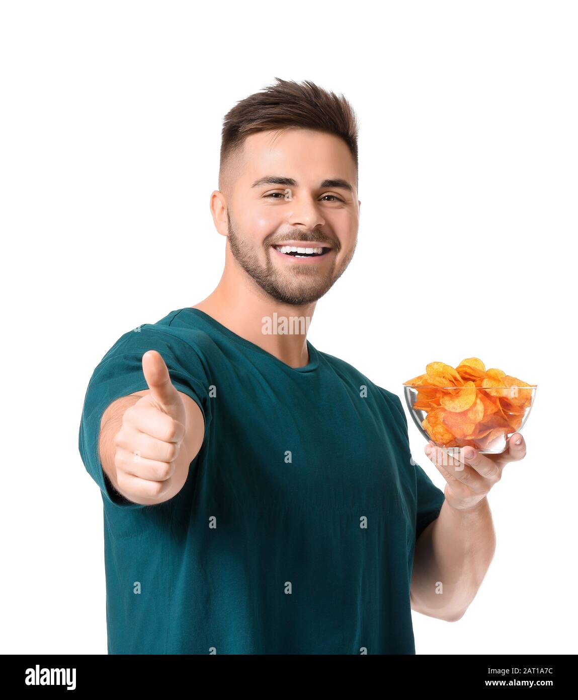 Handsome young man with tasty potato chips showing thumb-up on white ...