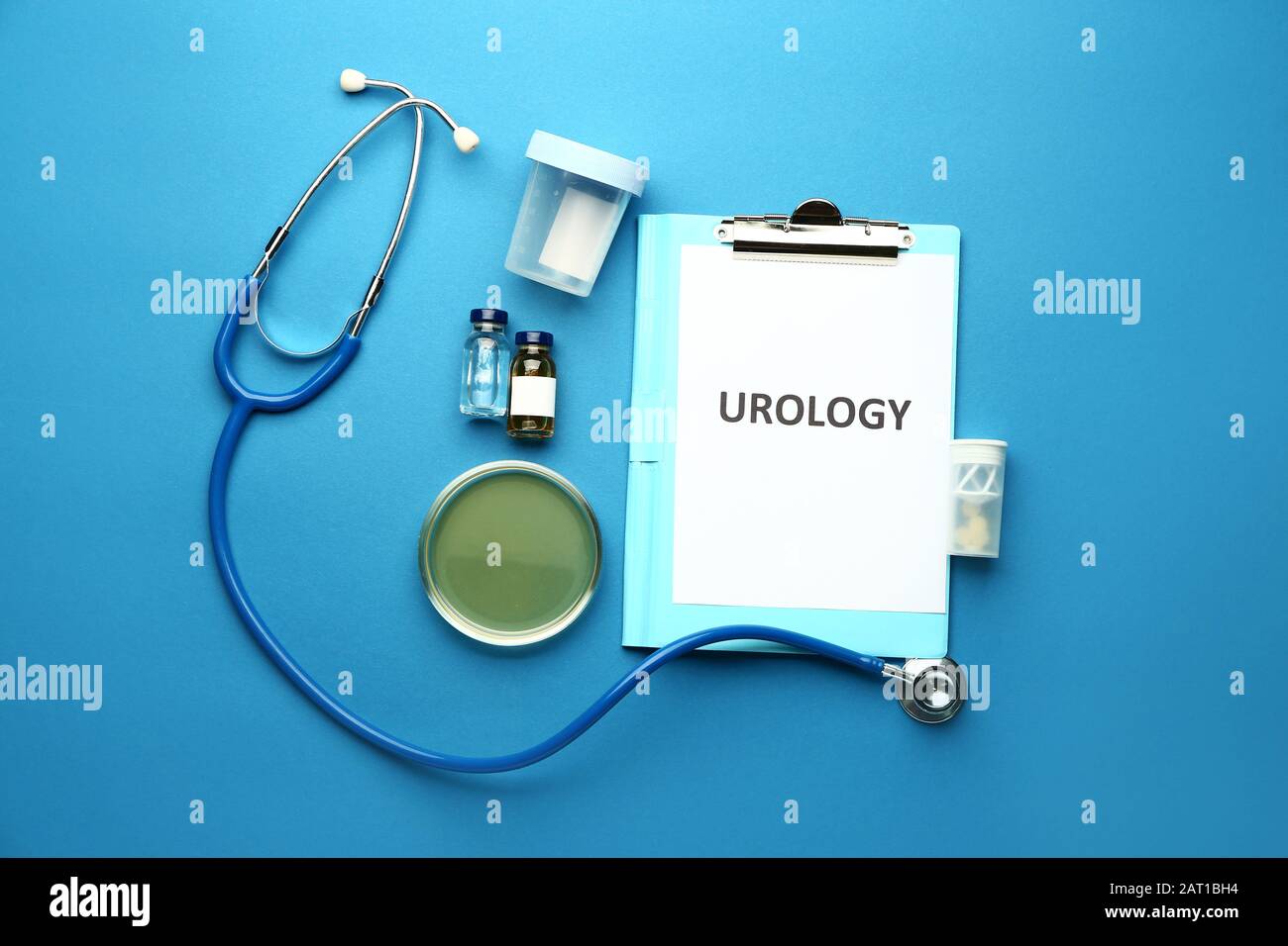 Clipboard with text UROLOGY, stethoscope, medicines and urine sample on ...