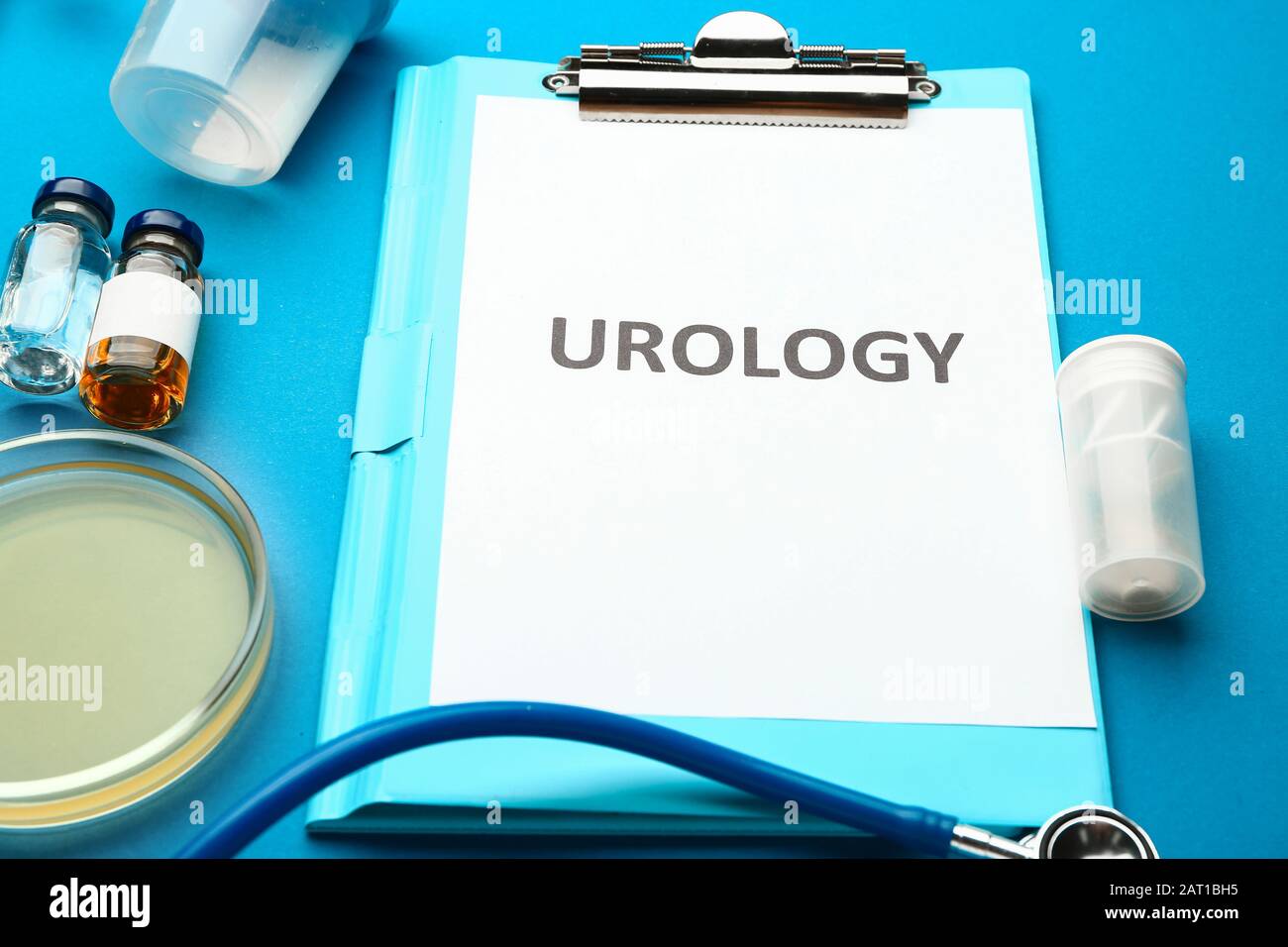 Clipboard with text UROLOGY, medicines and urine sample on color ...