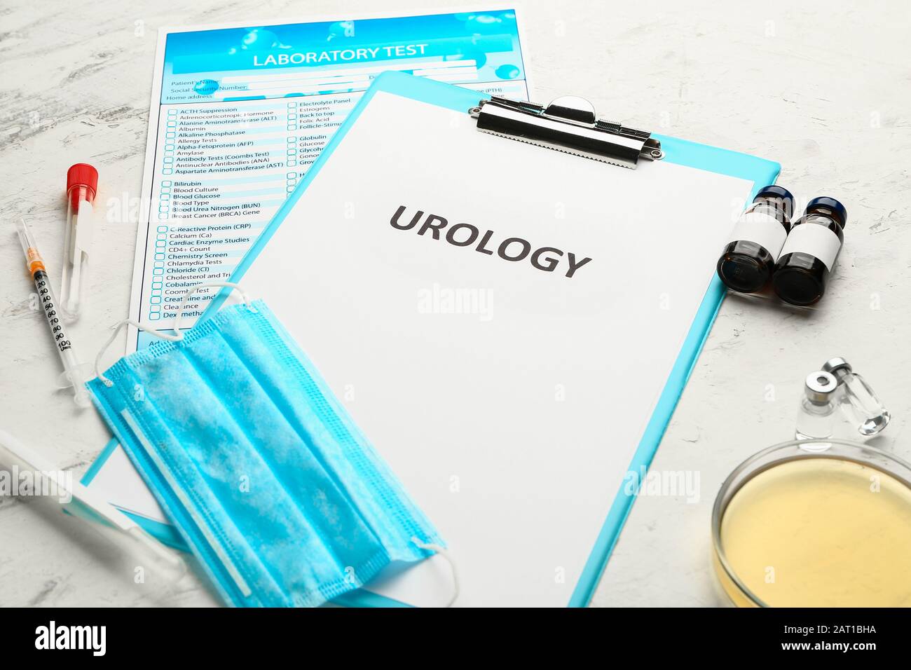 Clipboard with text UROLOGY, medicines and urine sample on white ...