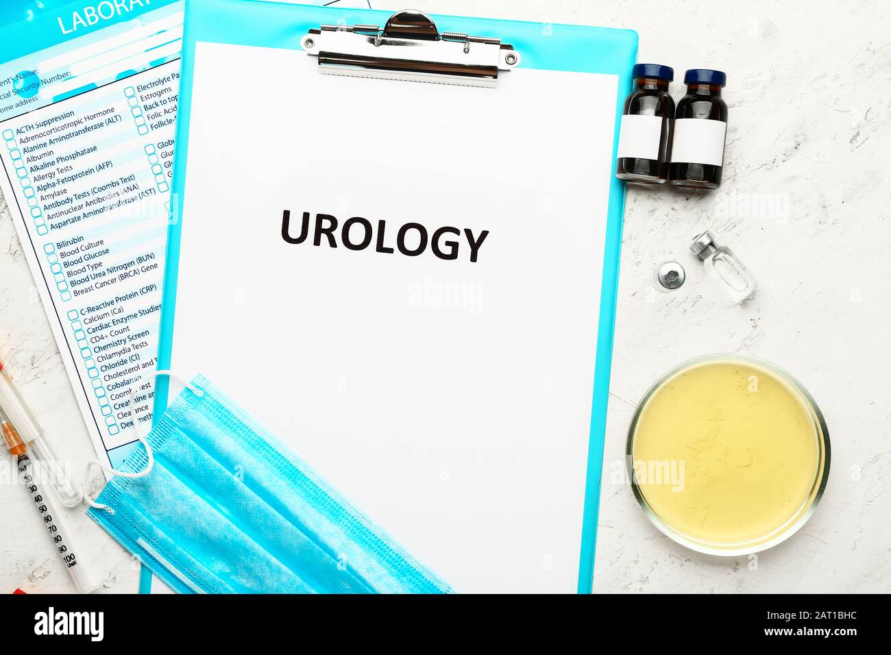 Clipboard with text UROLOGY, medicines and urine sample on white ...