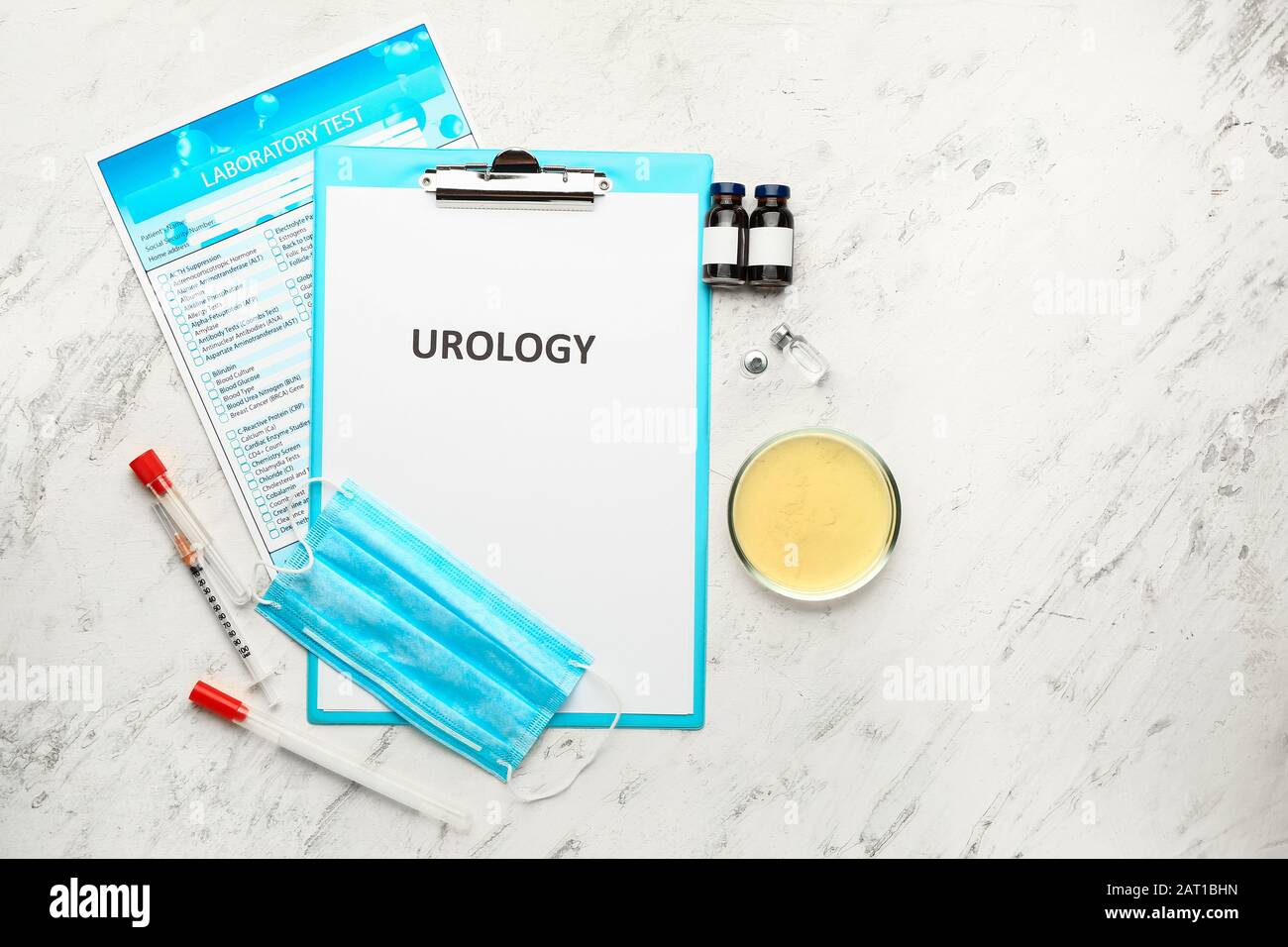 Clipboard with text UROLOGY, medicines and urine sample on white ...
