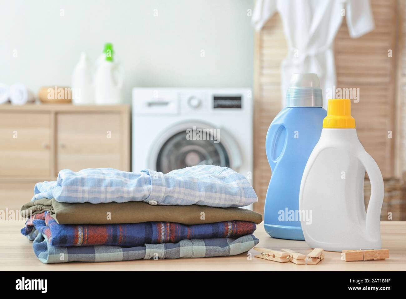 Clean laundry and washing liquid on table in bathroom Stock Photo - Alamy