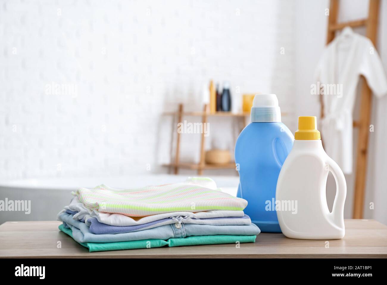 Clean laundry and washing liquid on table in bathroom Stock Photo - Alamy