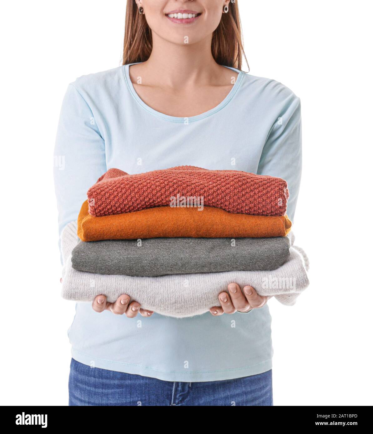 Young woman with clean laundry on white background Stock Photo - Alamy